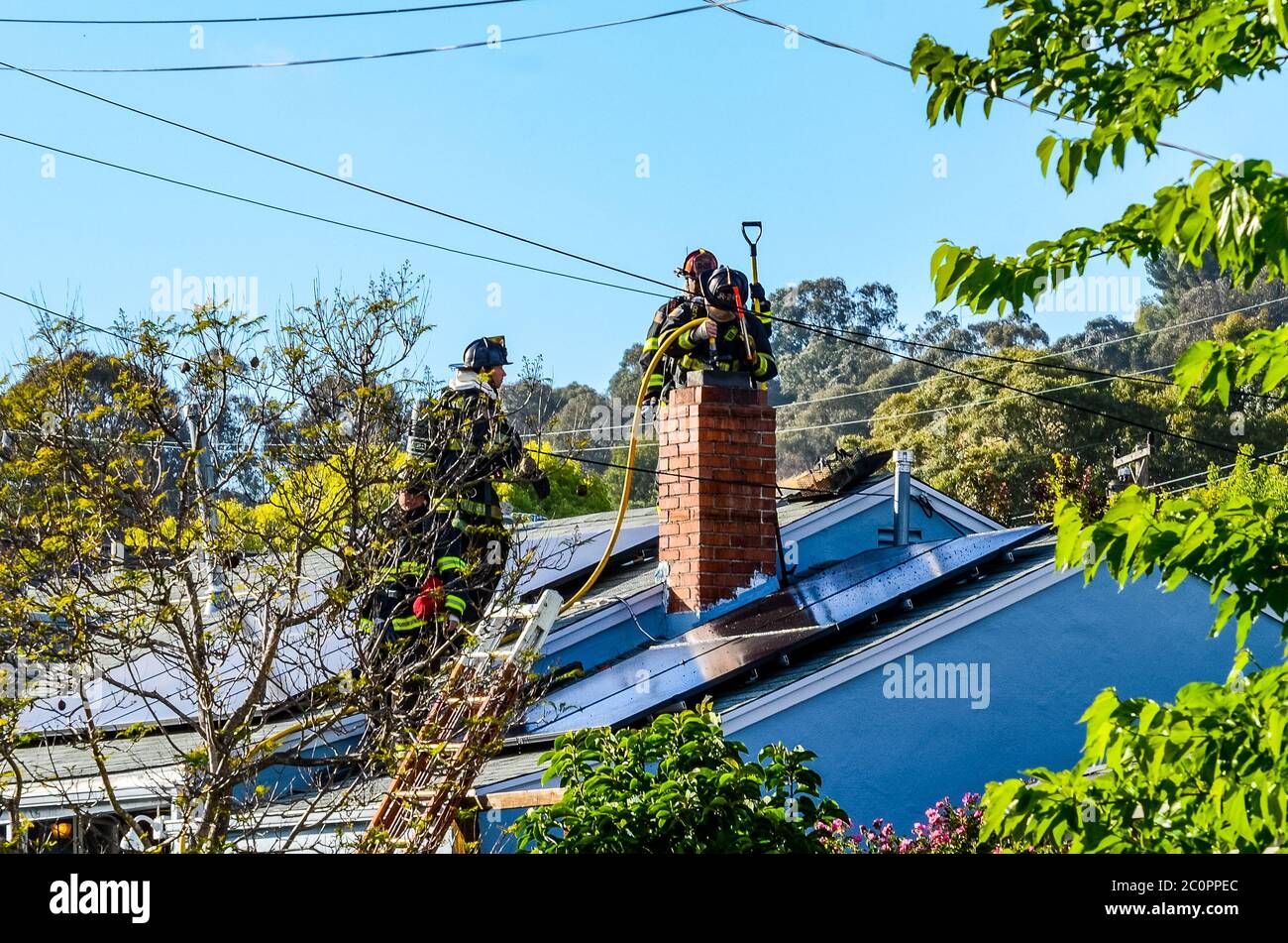 Alameda County fire department workers extinguish a chimney fire in San ...