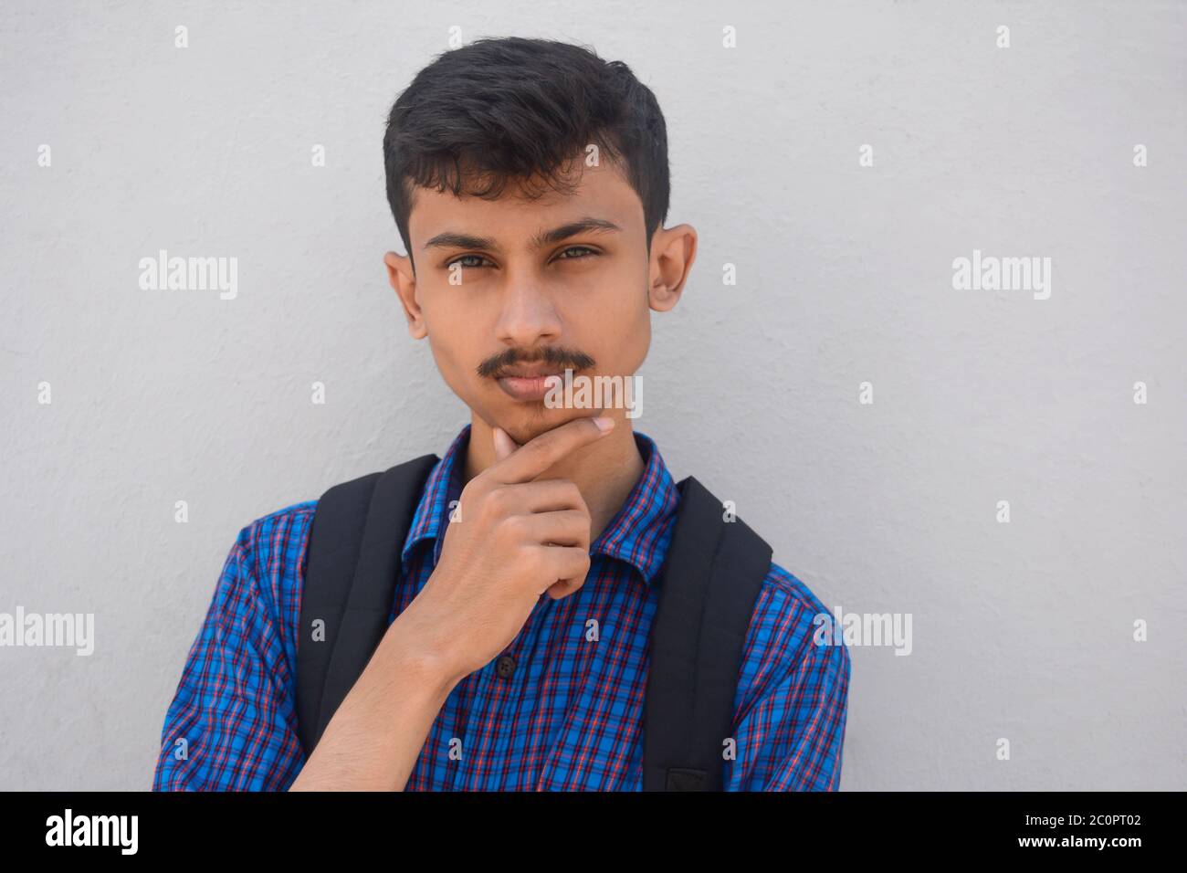 Portrait of teen thinking man looks up with hand near face.teen student ...