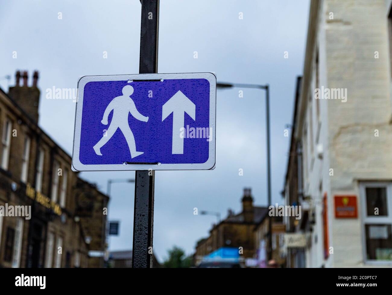 A blue and white pedestrian one way sign attached to a post during ...