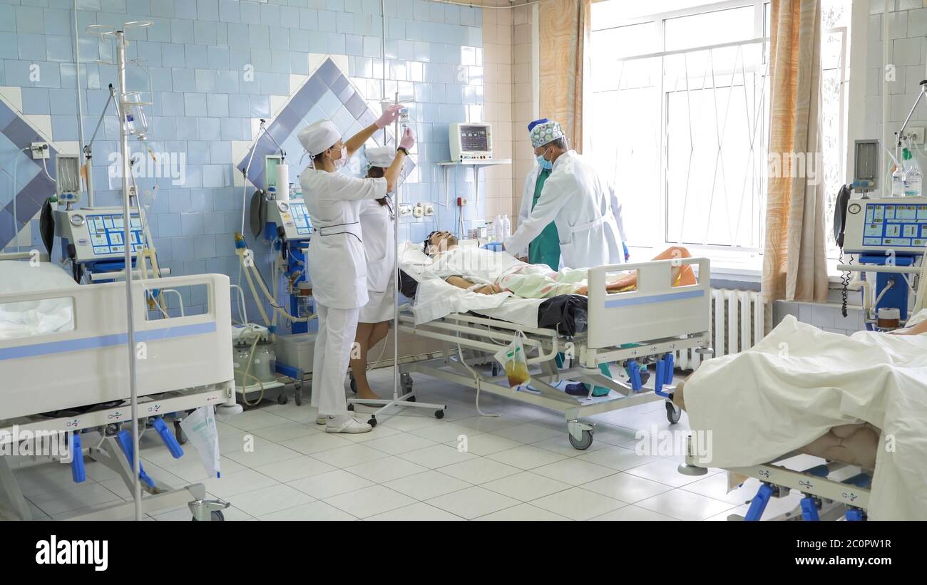 Group of doctors examines seriously ill patient in intensive care unit ...