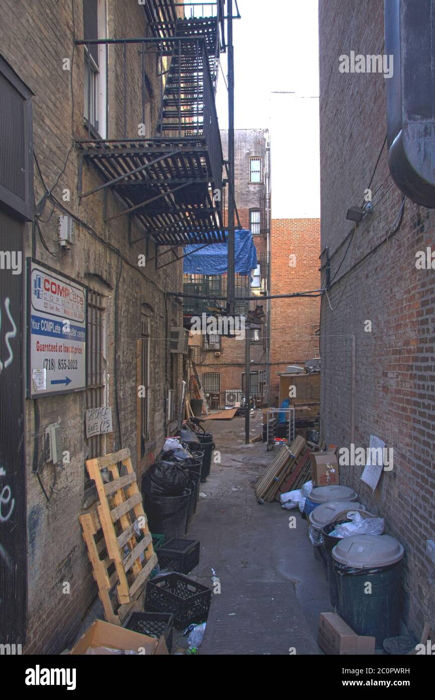 New York City alleyway with fire escape & various garbage / rubish on ...