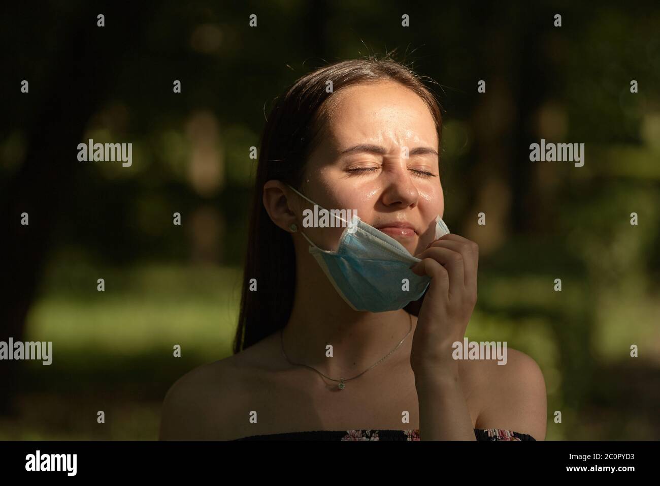 Girl resting in the park on a sunny summer day. Portrait of a woman ...