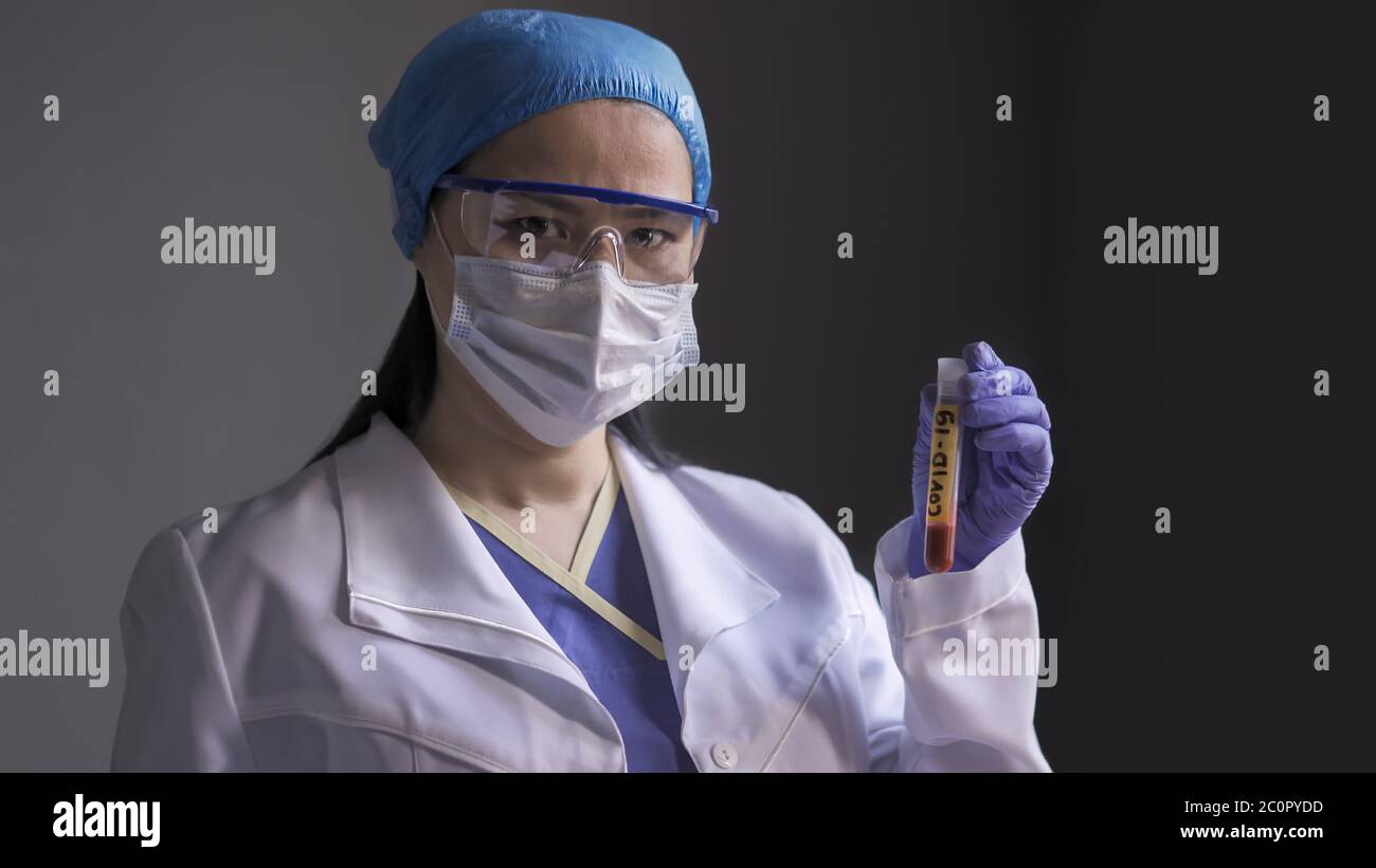 Medical lab worker holds test tube with blood for coronavirus test ...
