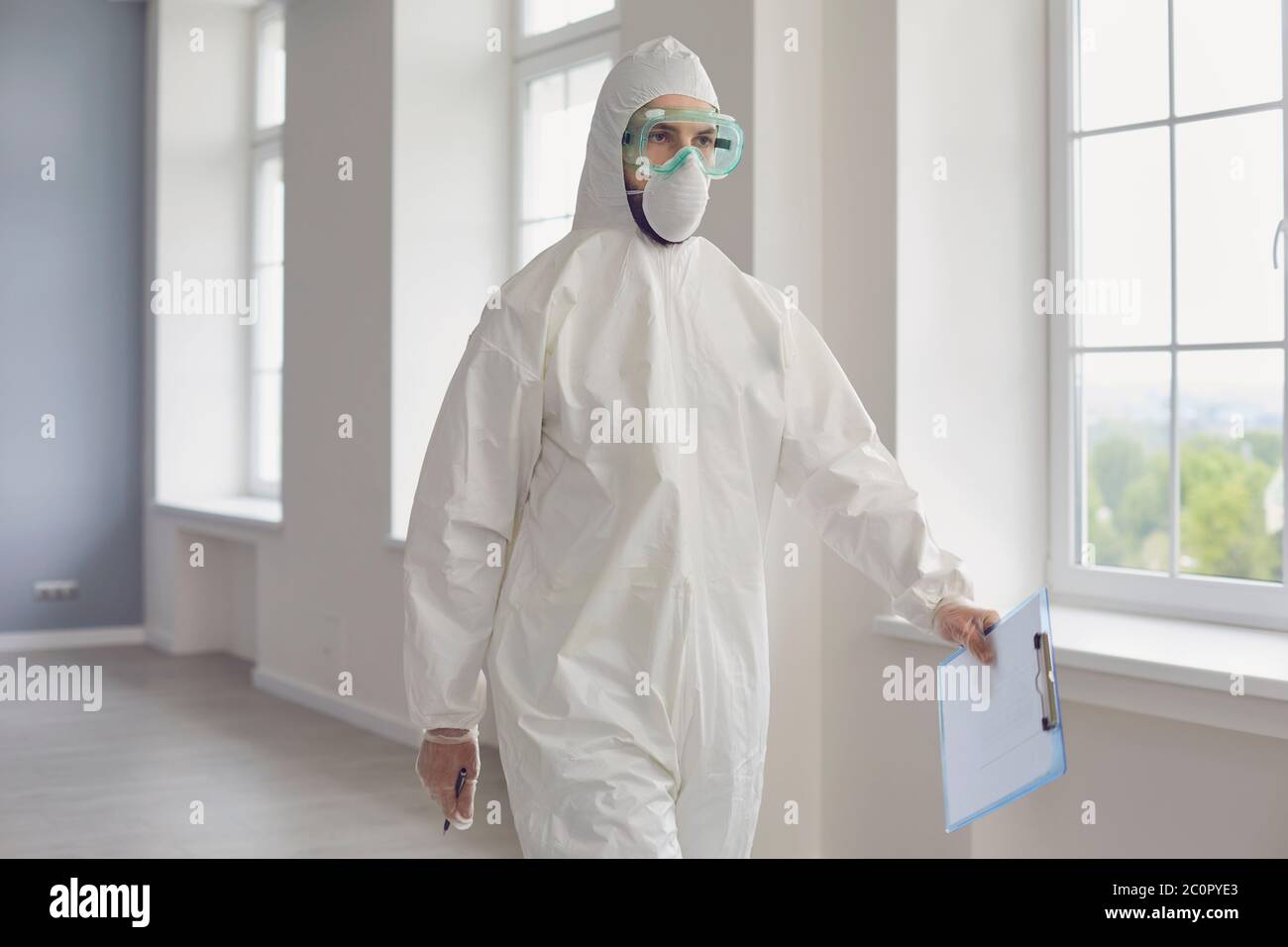 Doctor in protective wear walking along hospital hall. Medic in hazmat ...