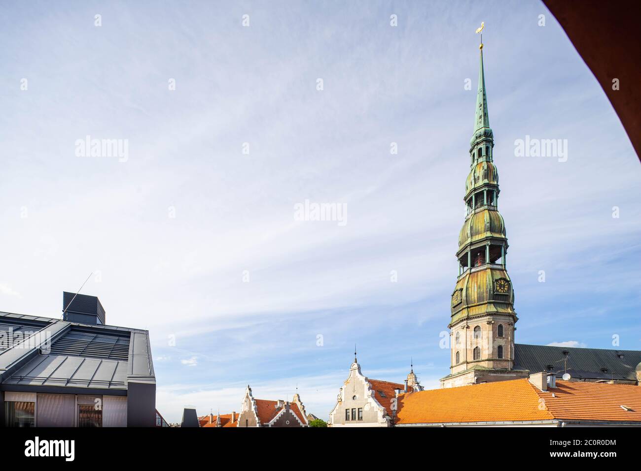 Sunny day in old town of Riga, Latvia. View of red tile roofs and St ...