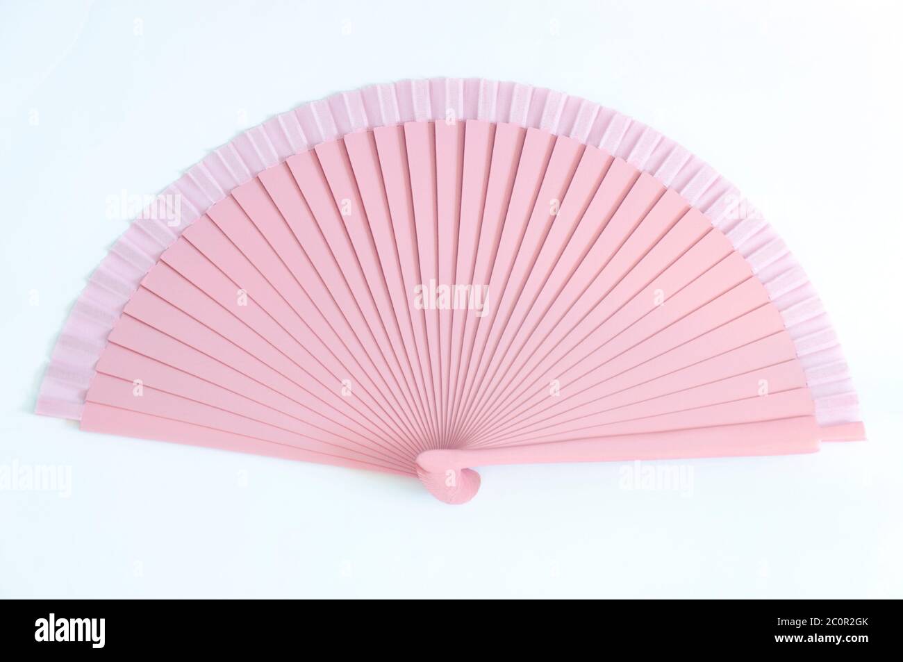 Pink spanish folding fan on a white background Stock Photo - Alamy