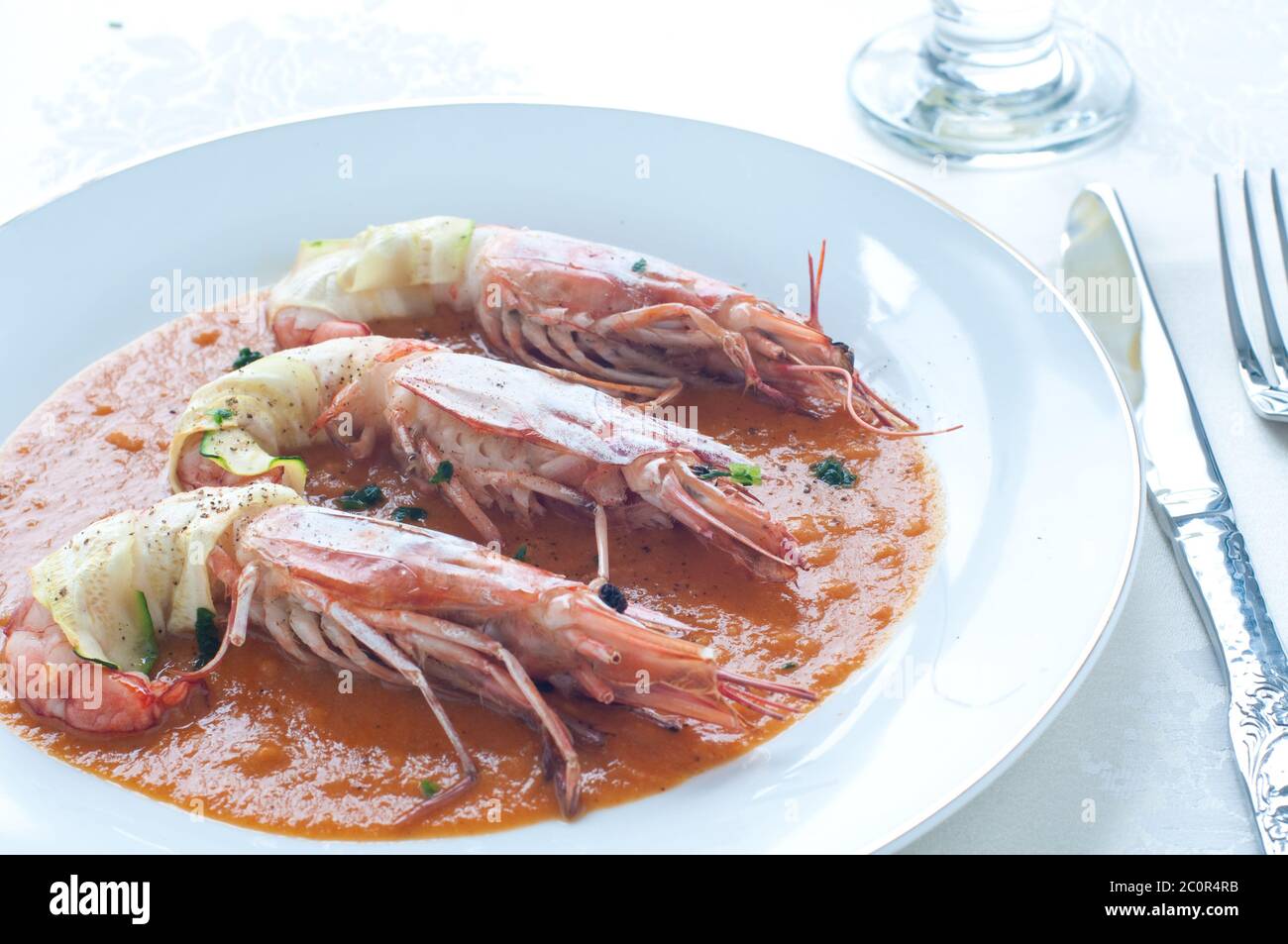 Prawns wrapped in zucchini with bisque sauce Stock Photo - Alamy