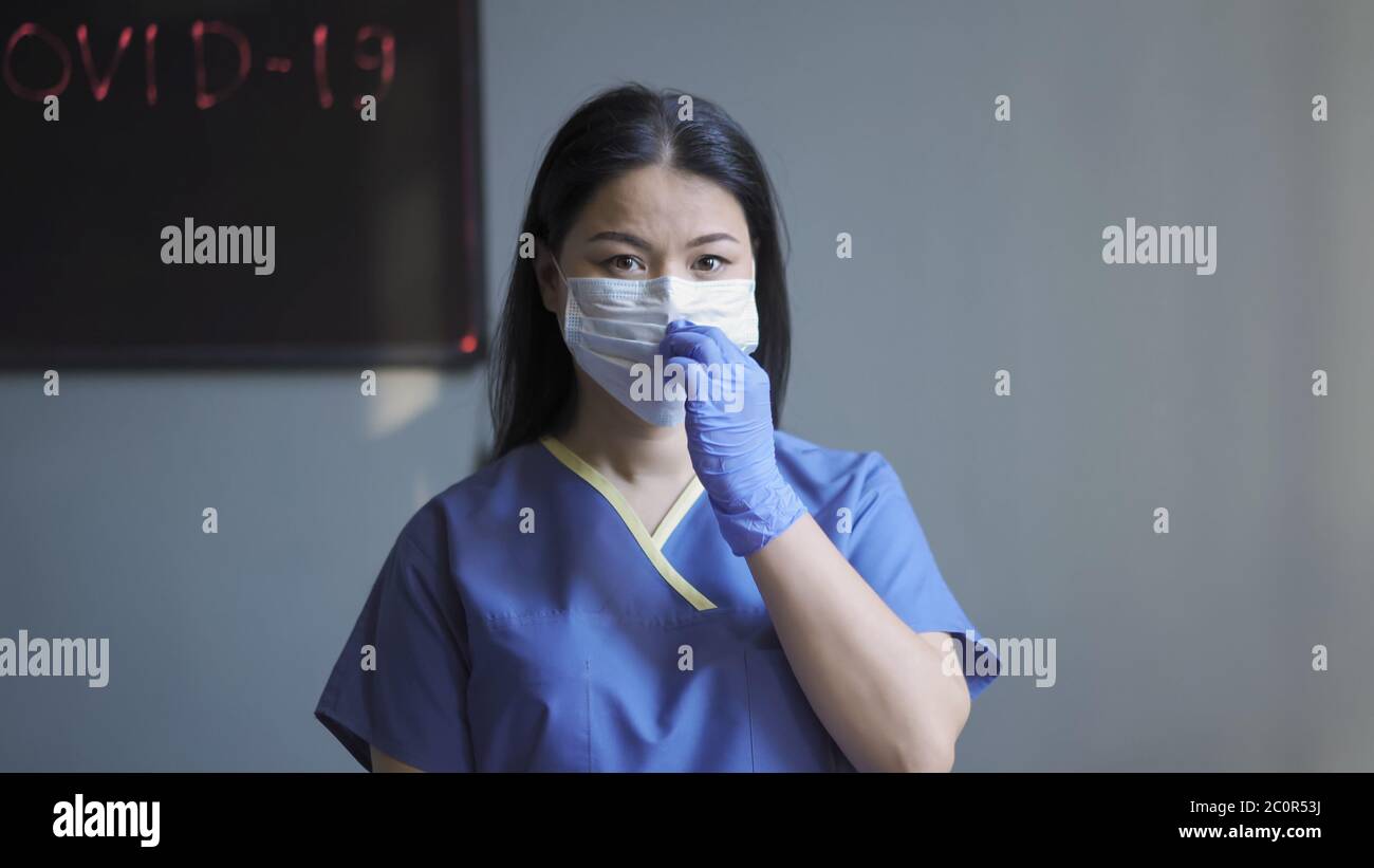 Masked doctor working in her office. Asian woman in mask and protective ...