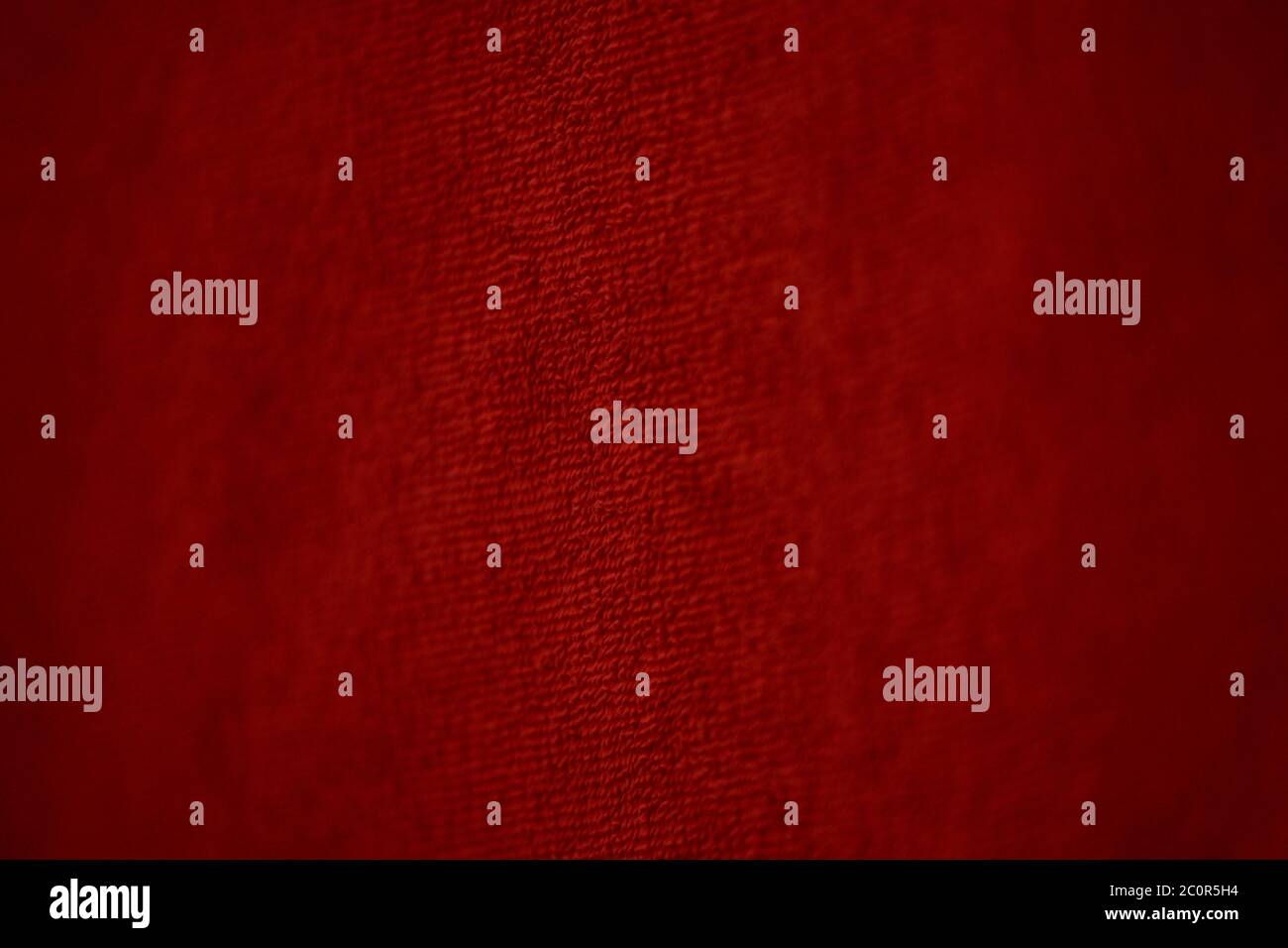 Blood red bath towel background. The texture of the fabric is red terry ...