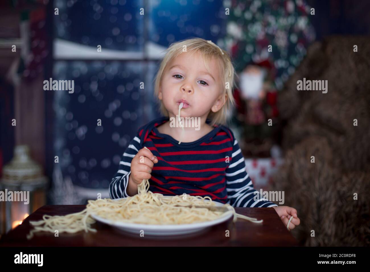 Sweet toddler child, boy, eating spaghetti at home on Christmas Stock ...