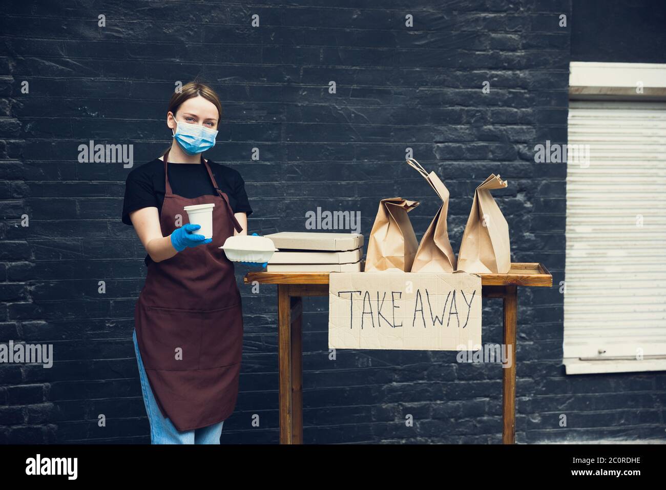 Protected. Woman preparing drinks and meals, wearing protective face ... Protected. Woman preparing drinks and meals, wearing protective face ...