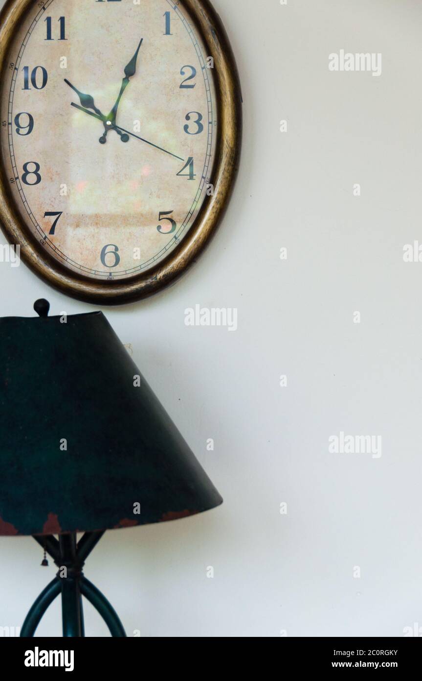 Old watch hanging on wall with lamp and lampshade Stock Photo - Alamy