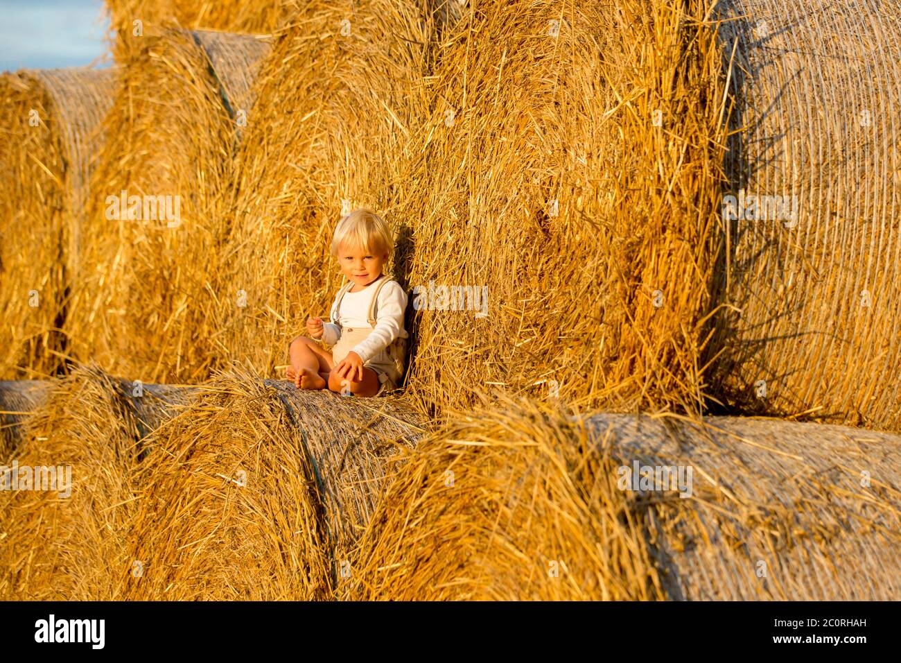 Happy children, playing on haystacks in a field, summertime Stock Photo ...