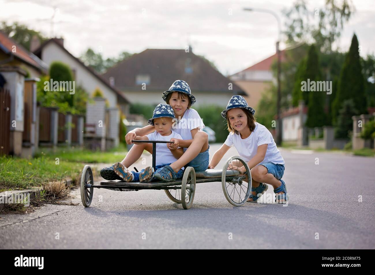 Happy children, boy brothers, riding old retro car with four wheels in ...