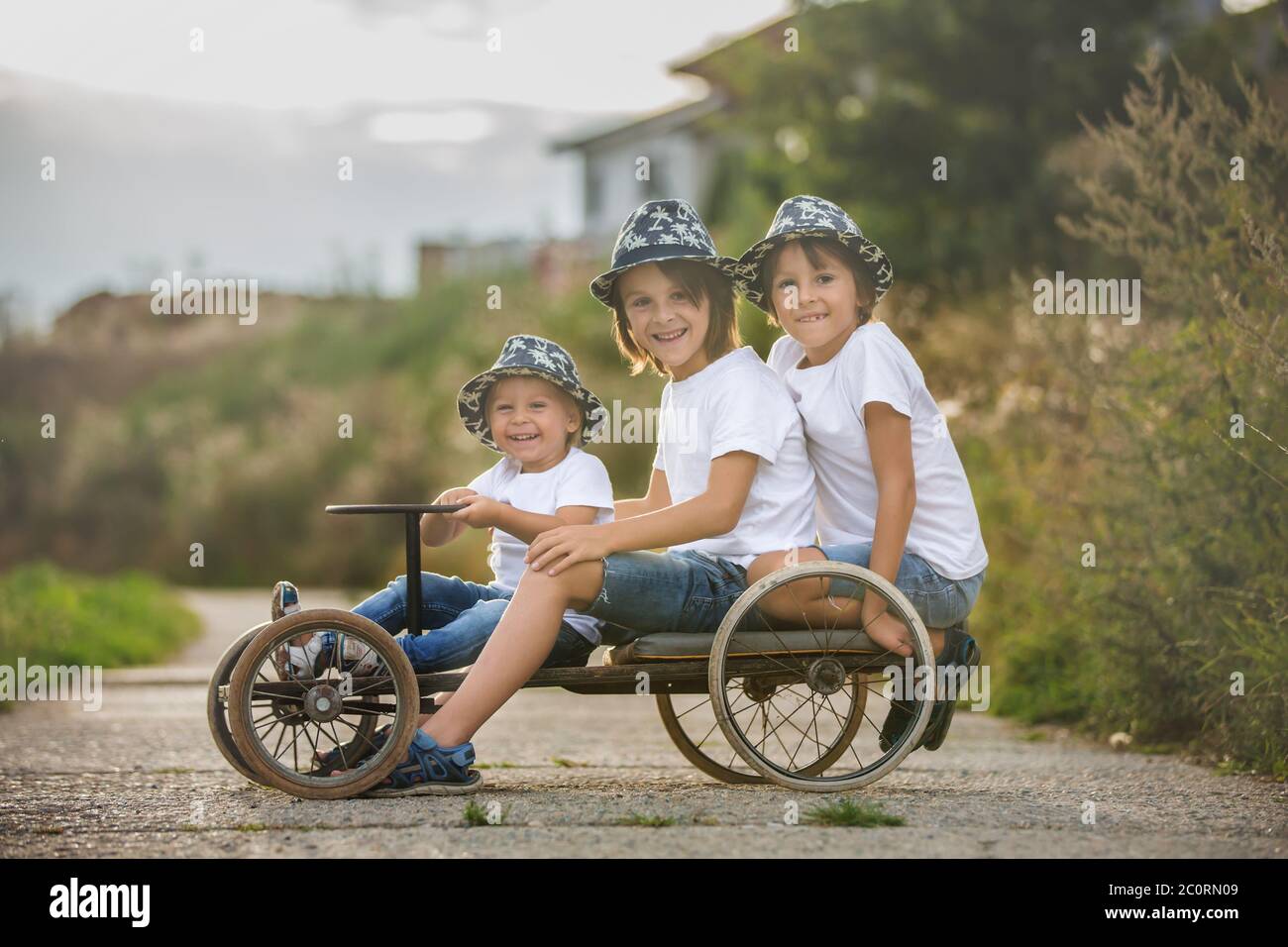 Happy children, boy brothers, riding old retro car with four wheels in ...