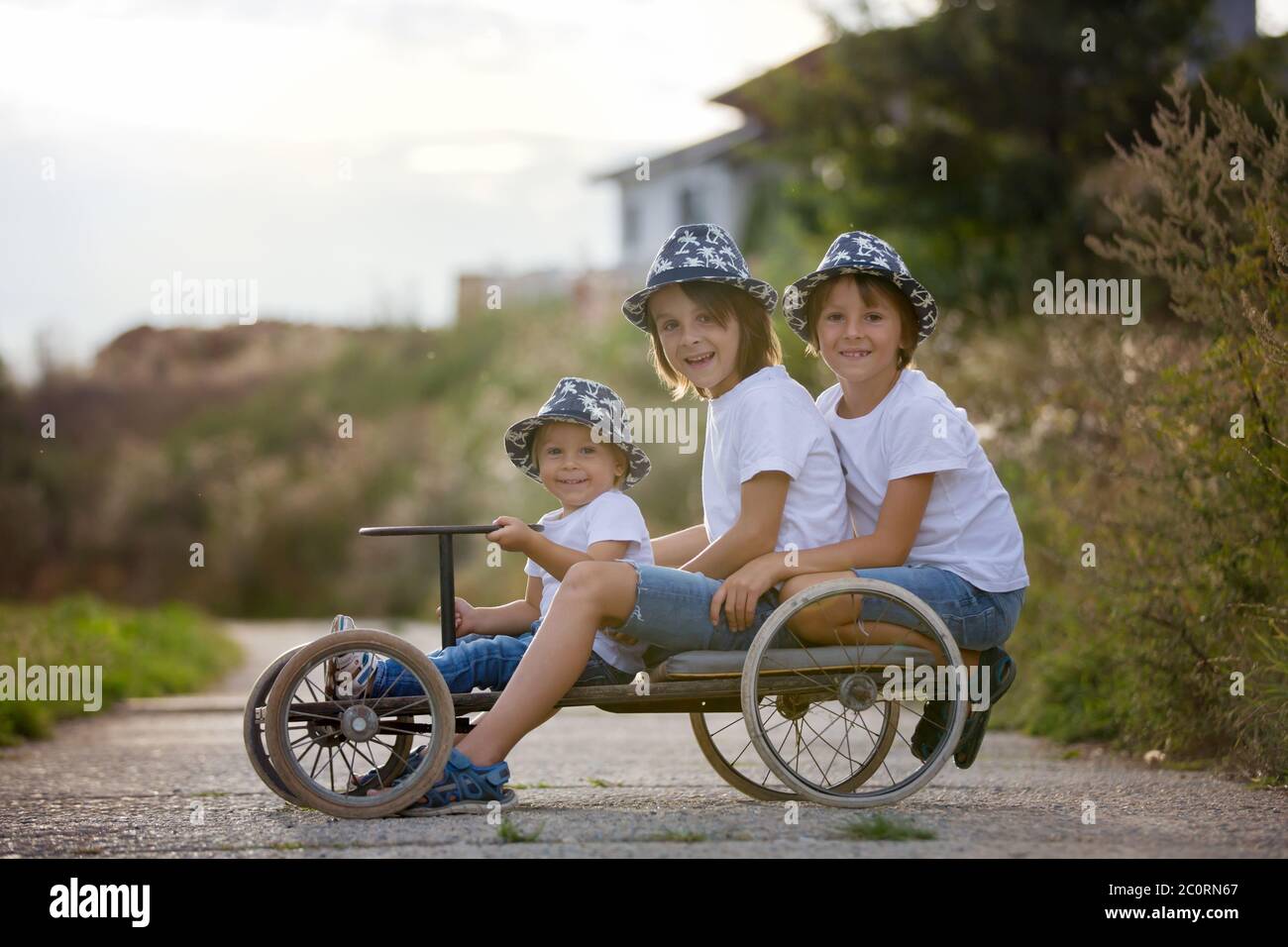 Happy children, boy brothers, riding old retro car with four wheels in ...