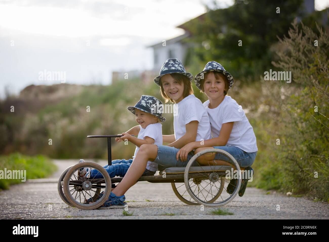 Happy children, boy brothers, riding old retro car with four wheels in ...