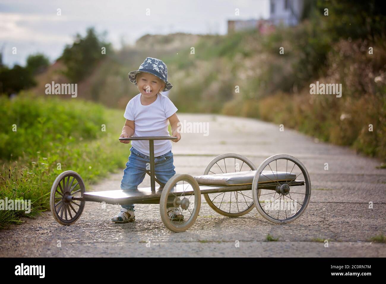 Adorable toddler boy, riding old retro car with four wheels in a ...