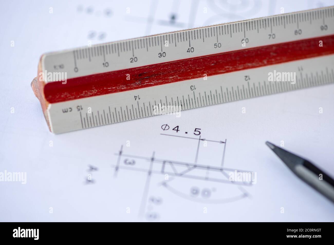 Close-up of a wooden ruler with a blueprint and black pencil in the ...