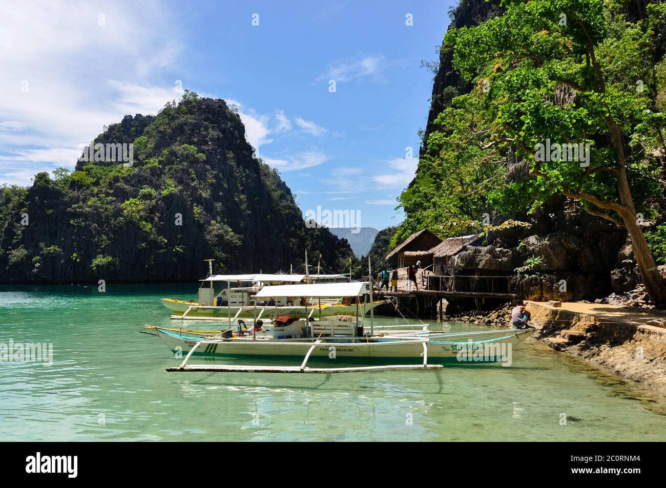 Traditional wooden filipino boats in a blue lagoon at tropical island ...