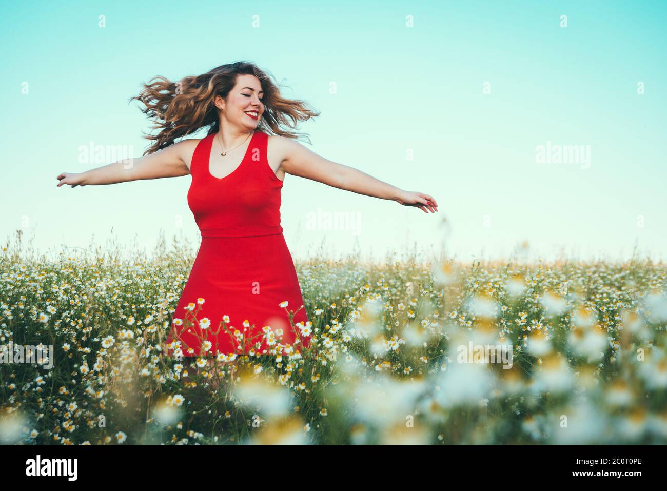 blonde woman with red dress spinning in the field Stock Photo - Alamy