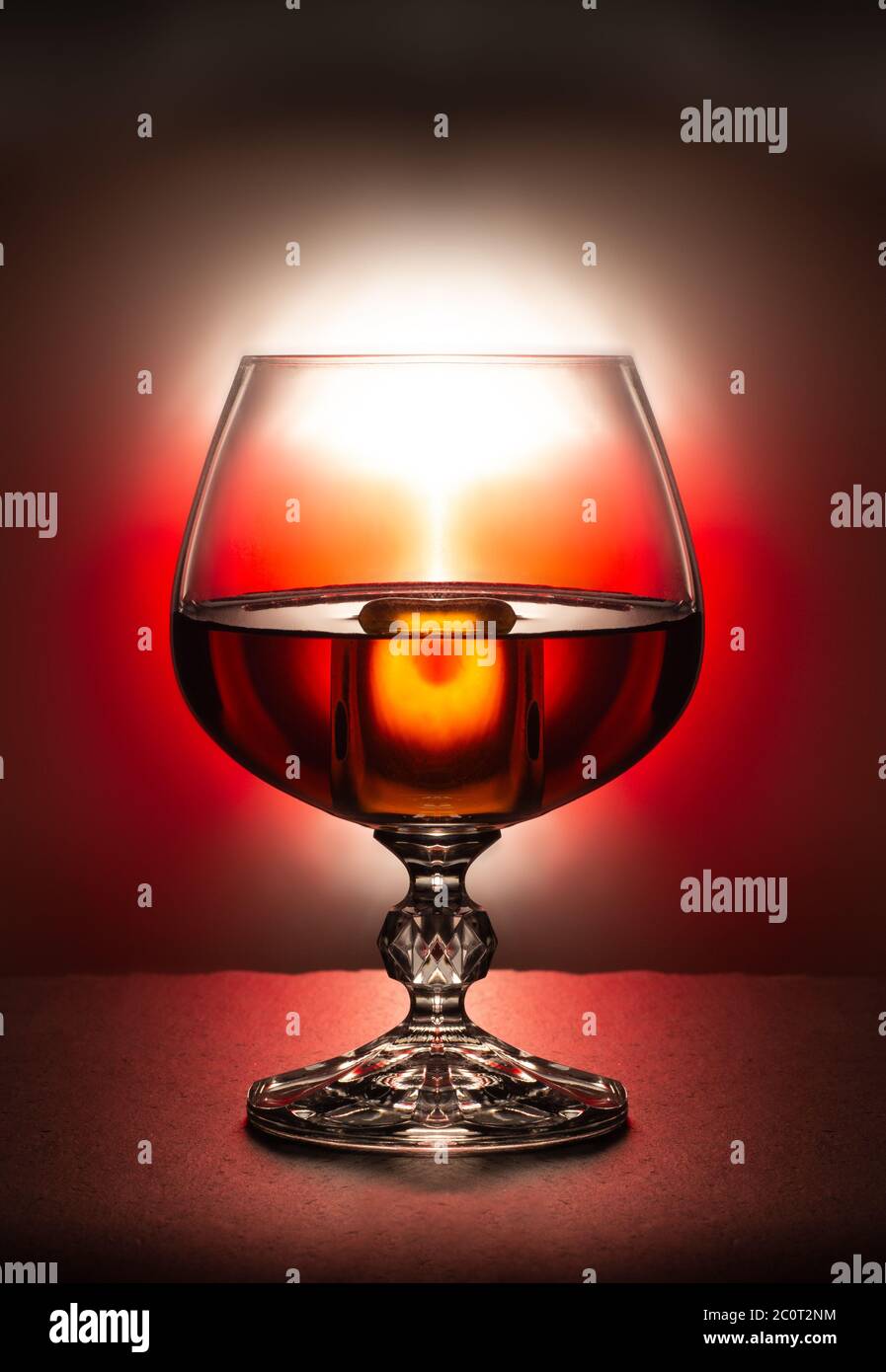 A glass of brandy on a red background Stock Photo - Alamy