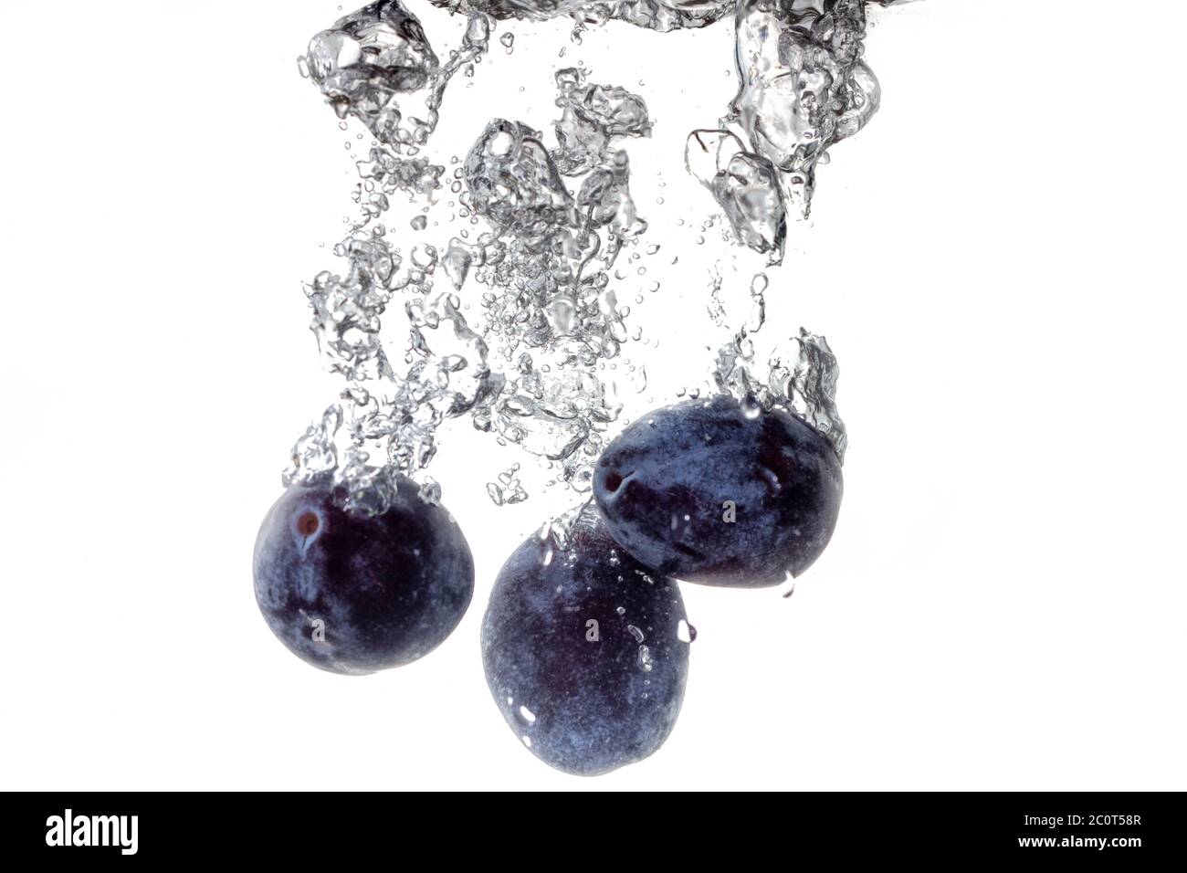 Plums falling into water, isolated on a white background Stock Photo ...