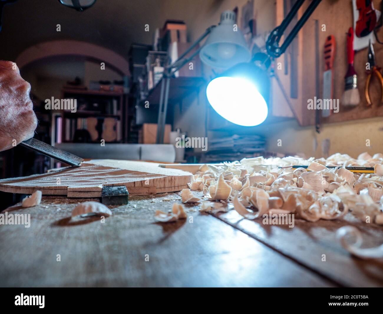 Professional luthier violinmaker artisan working on making a handmade ...