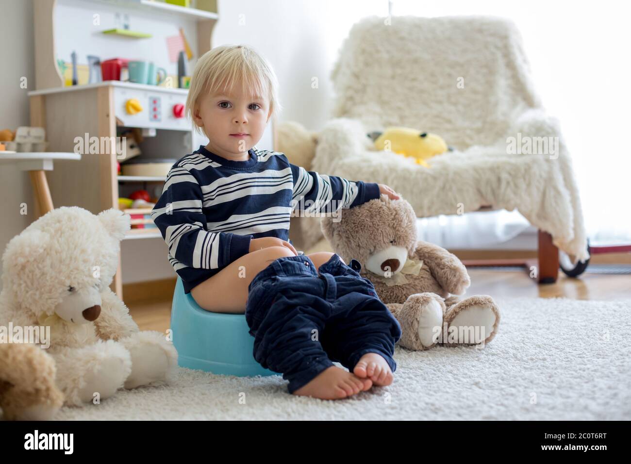 Cute toddler boy, potty training, playing with his teddy bear on potty ...