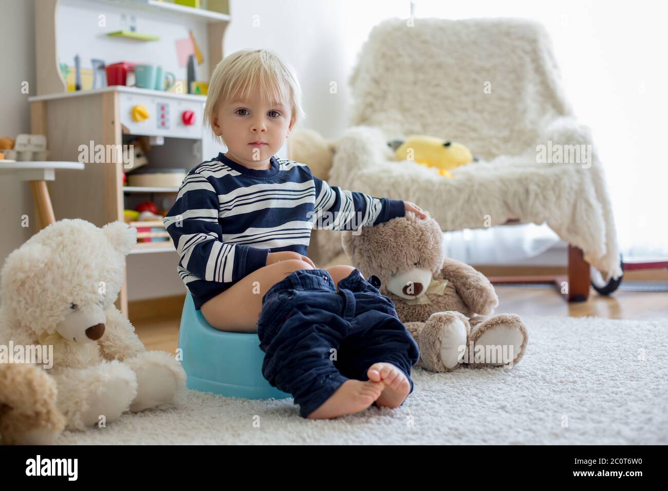 Cute toddler boy, potty training, playing with his teddy bear on potty ...