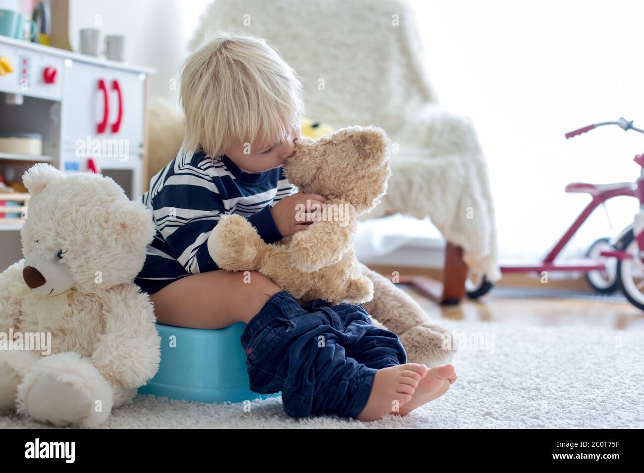 Cute toddler boy, potty training, playing with his teddy bear on potty ...