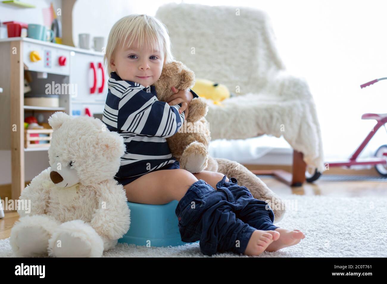 Cute toddler boy, potty training, playing with his teddy bear on potty ...