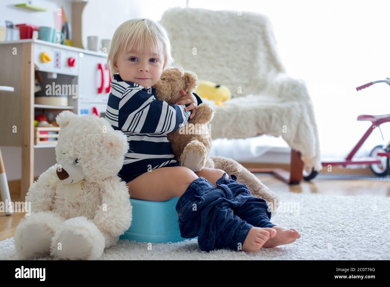 Cute toddler boy, potty training, playing with his teddy bear on potty ...