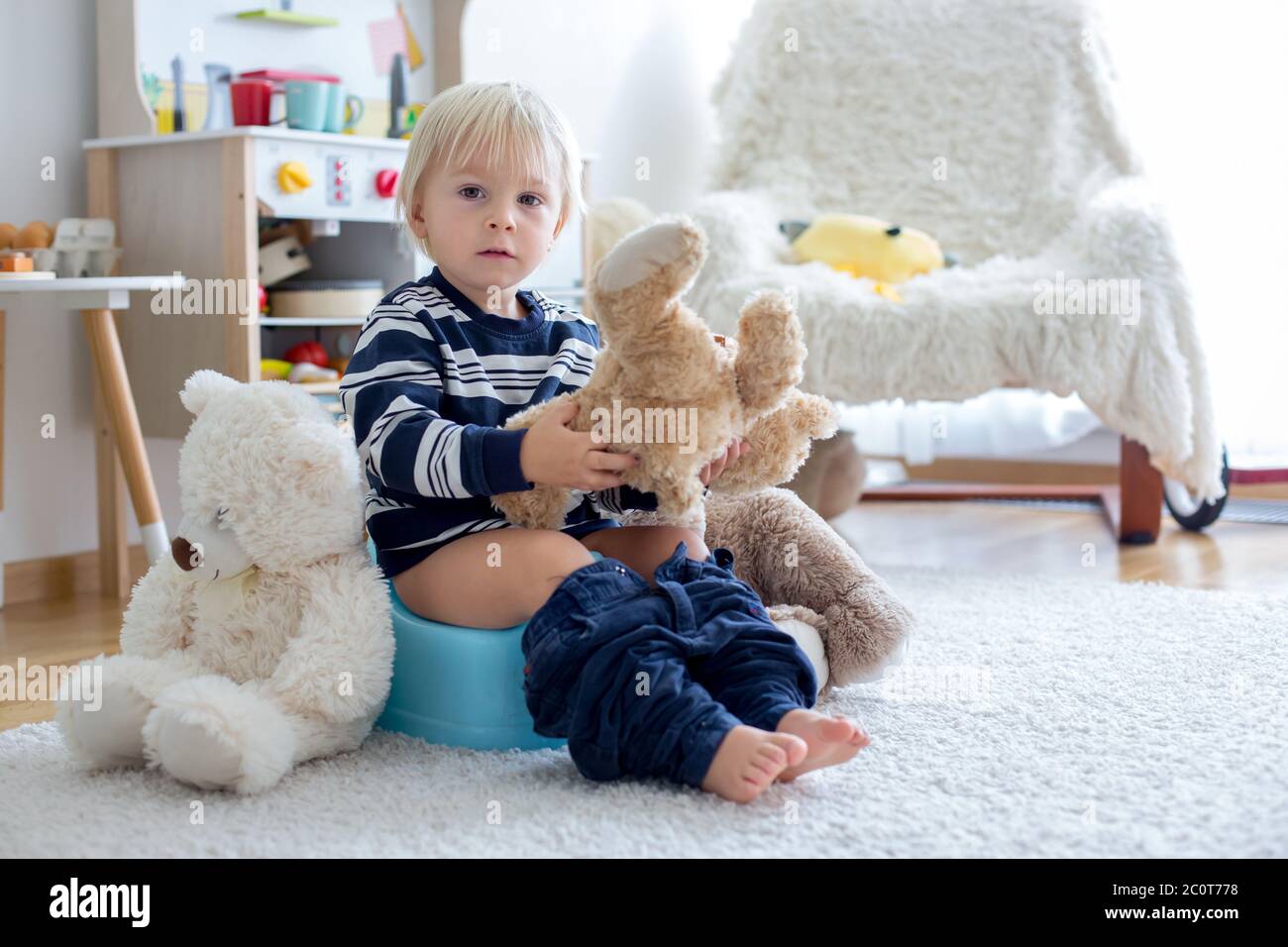 Cute toddler boy, potty training, playing with his teddy bear on potty ...