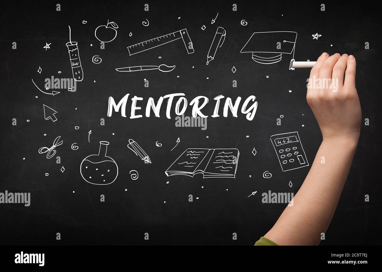 Hand drawing MENTORING inscription with white chalk on blackboard ...
