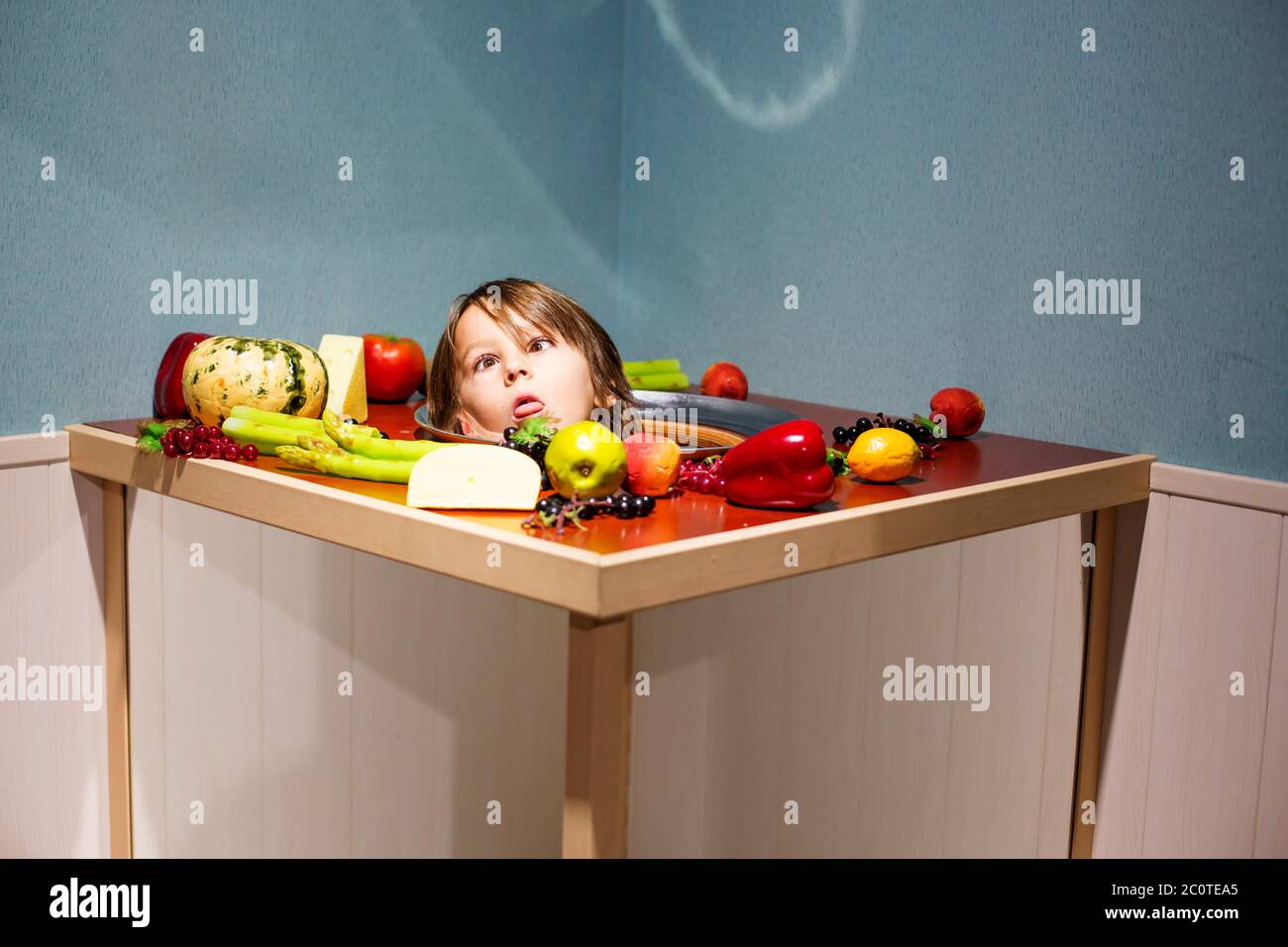 Kid, boy playing in a funny panel with plate and vegetables and his ...