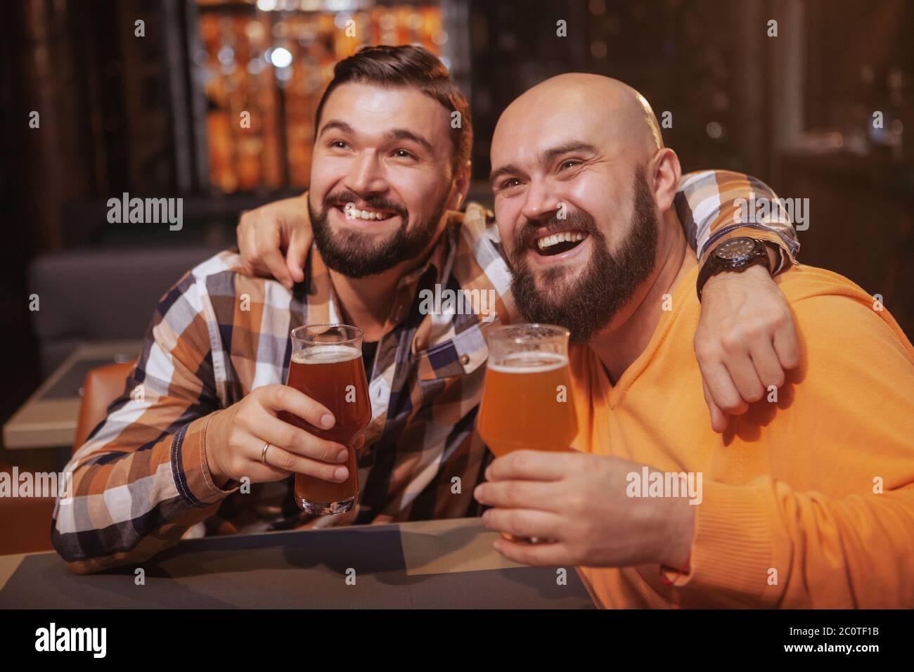 Happy bearded man enjoying drinking beer with his best friend. Male ...