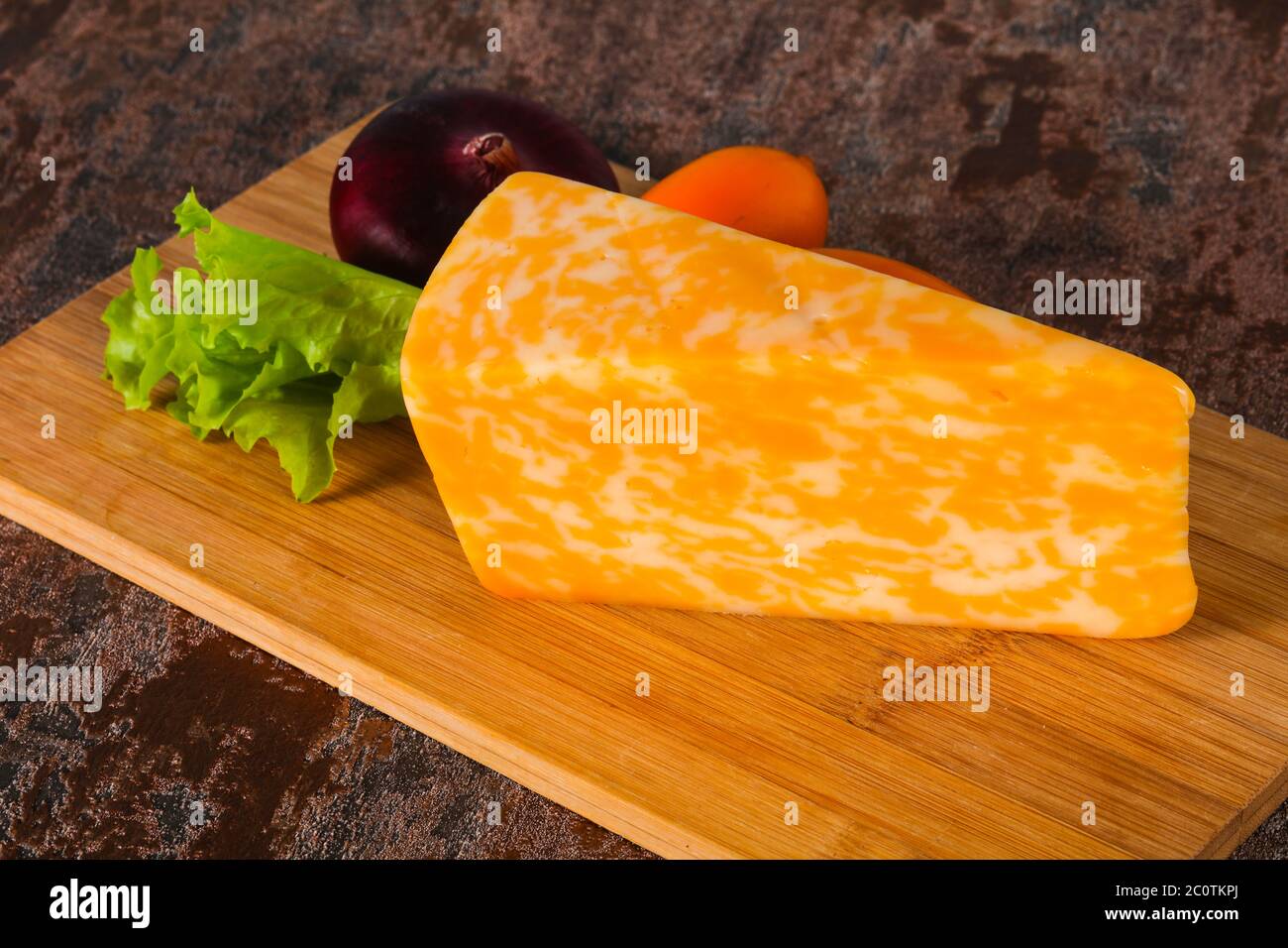 Marble cheese triangle over wooden background Stock Photo - Alamy
