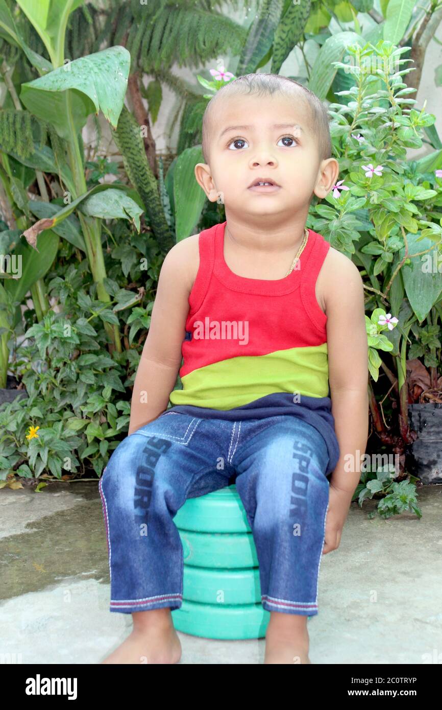 two years old little child seating in home garden, portrait of Asian ...