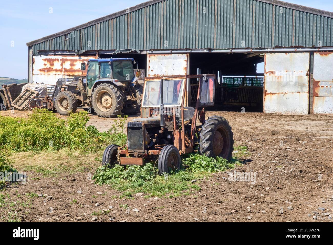 Old and newer tractors outside a farm building in Isle of Man Stock ...