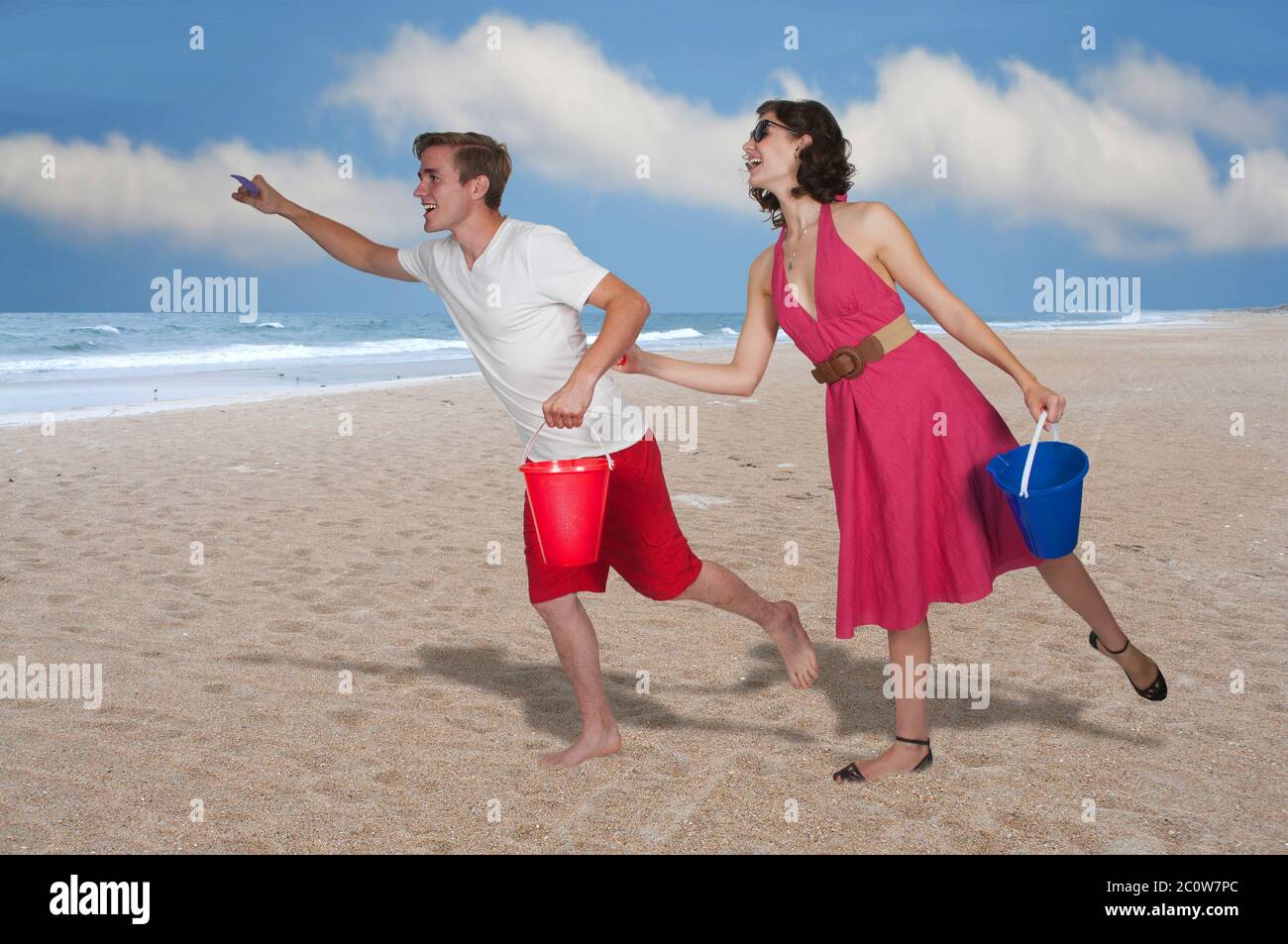 Couple running with a sand pail Stock Photo - Alamy
