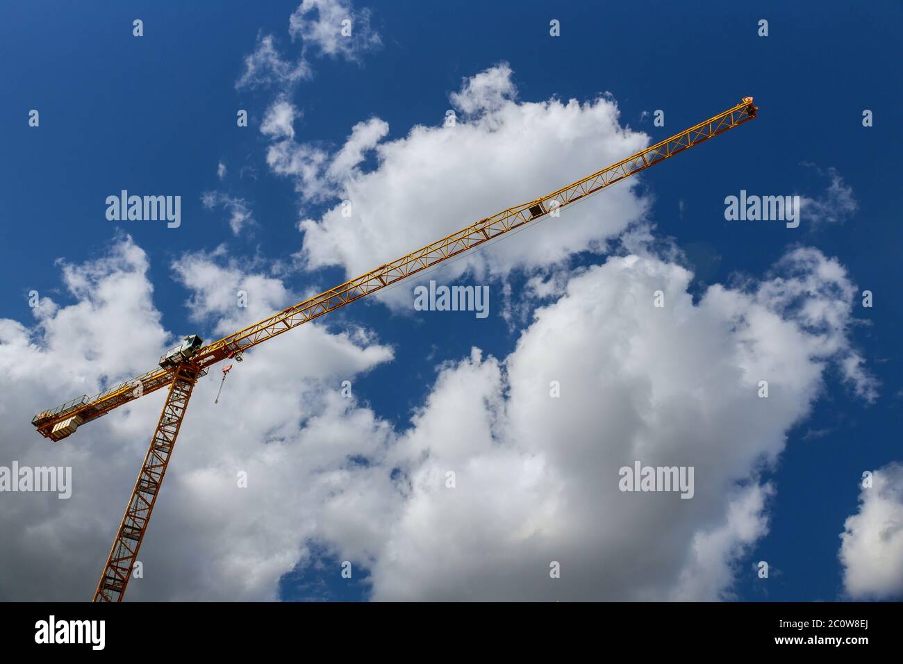 High rise building construction with tower crane against clear blue sky ...