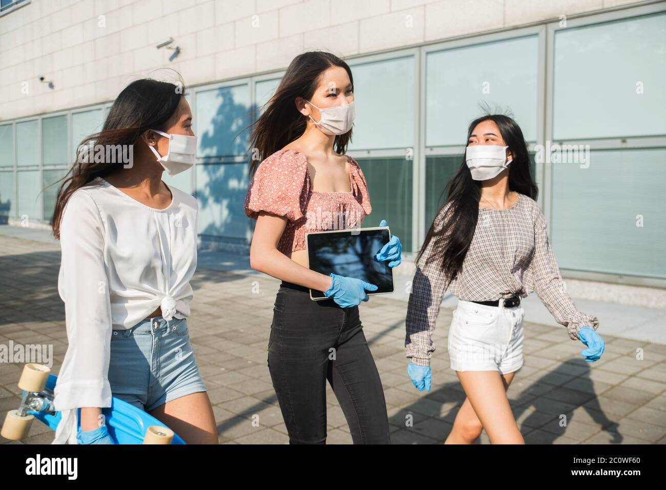 Asian girls with face masks bonding outdoors during pandemic and social ...