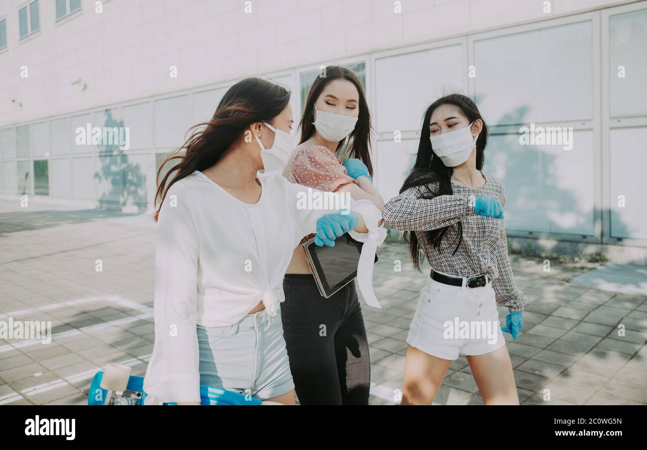 Asian girls with face masks bonding outdoors during pandemic and social ...