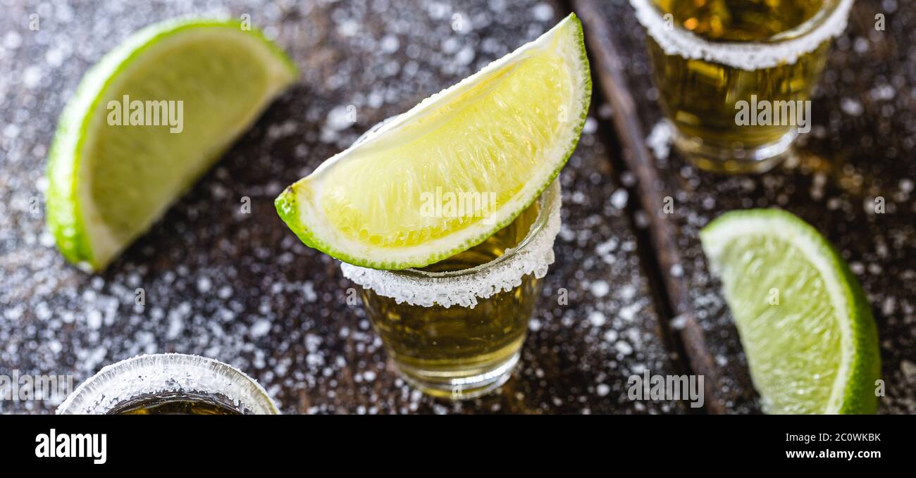 small glass of tequila, fiery drink from mexico. Lemon, coarse salt on ...