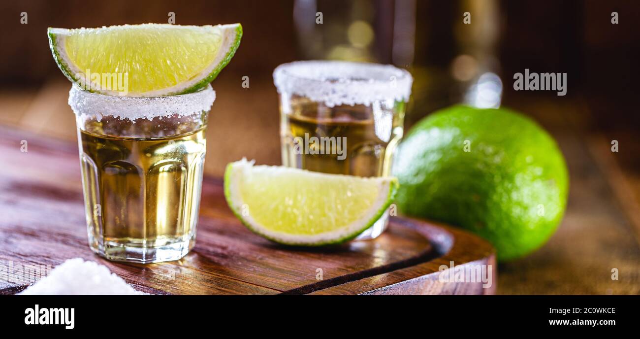small glass of tequila, fiery drink from mexico. Lemon, coarse salt on ...
