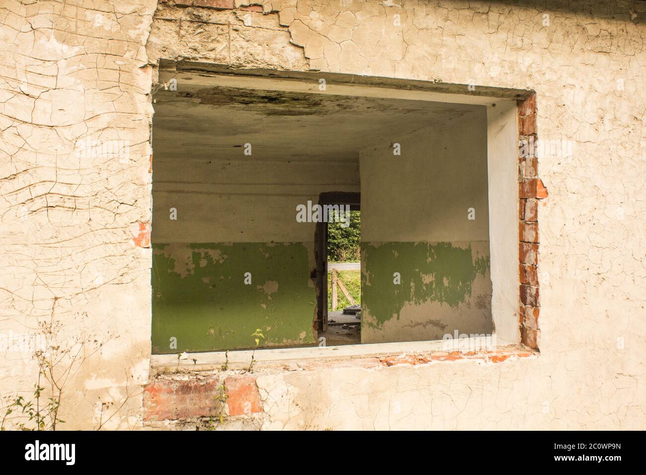 View of the derelict house interior hrough an empty window frame, the ...