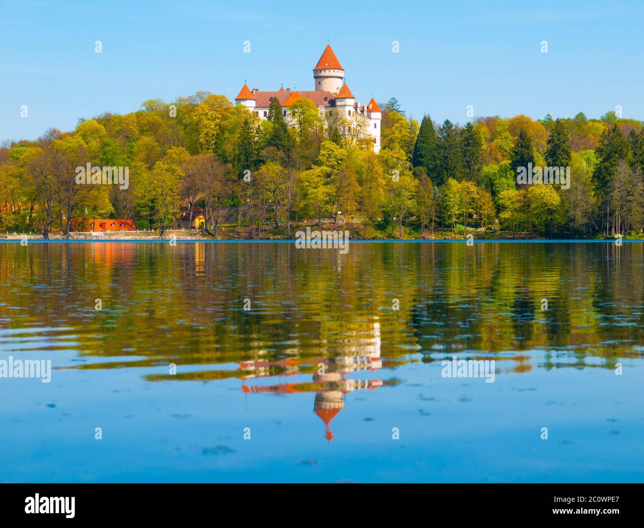 Chateau Konopiste with typical rounded tower reflecting in the water ...