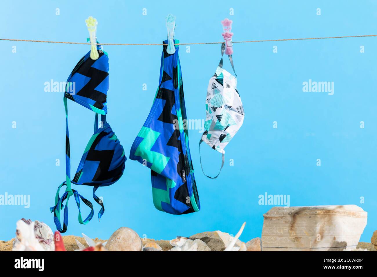 Women's swimsuit hangs on a string. Sea beach with wet sand Stock Photo ...