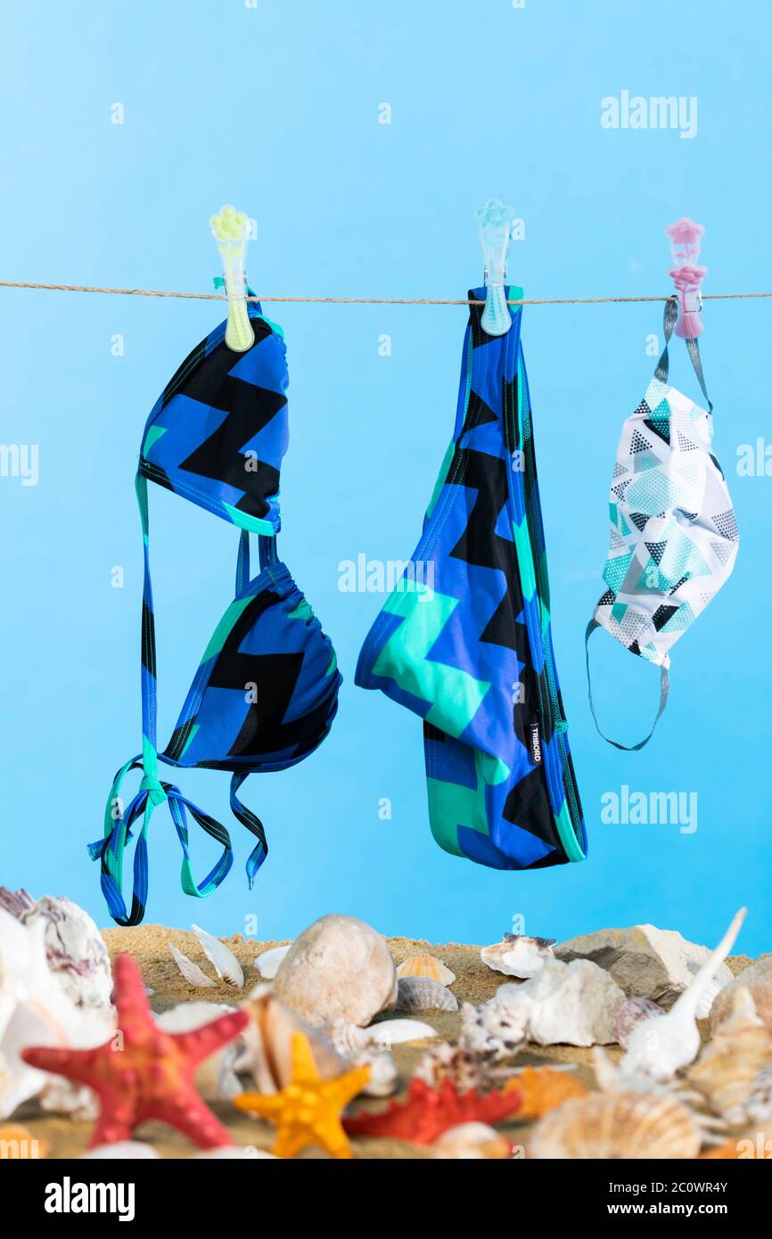 Women's swimsuit hangs on a string. Sea beach with wet sand Stock Photo ...